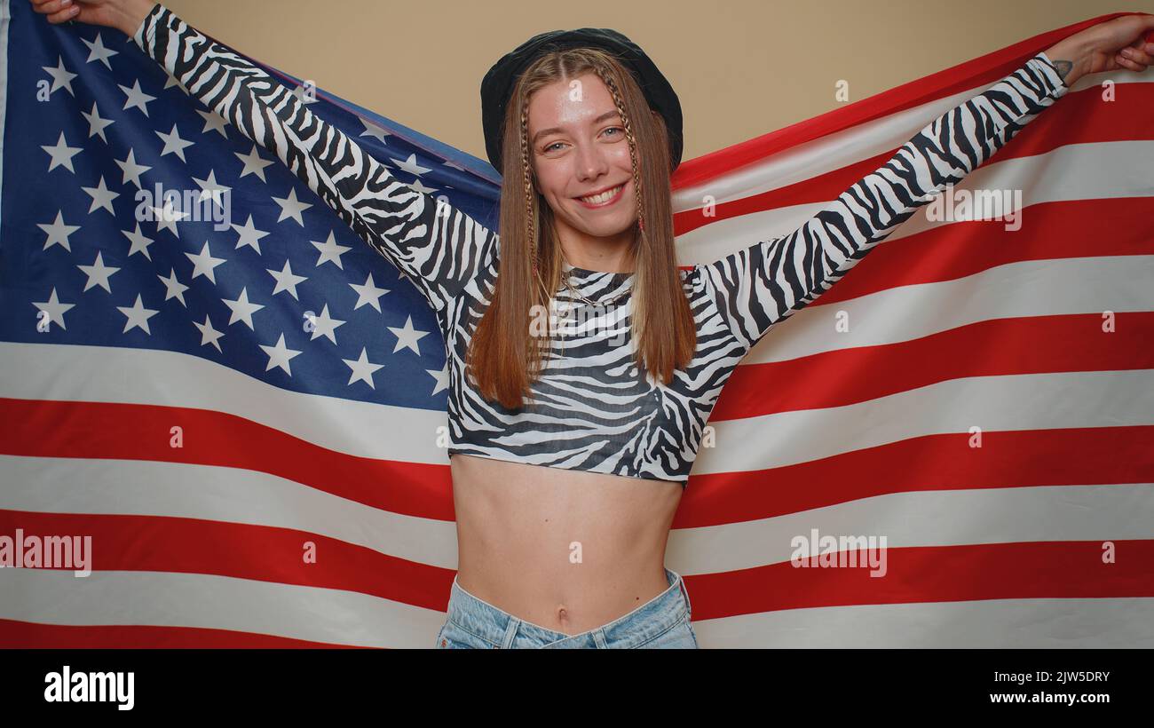 Lovely young woman in crop top waving and wrapping in American USA flag ...