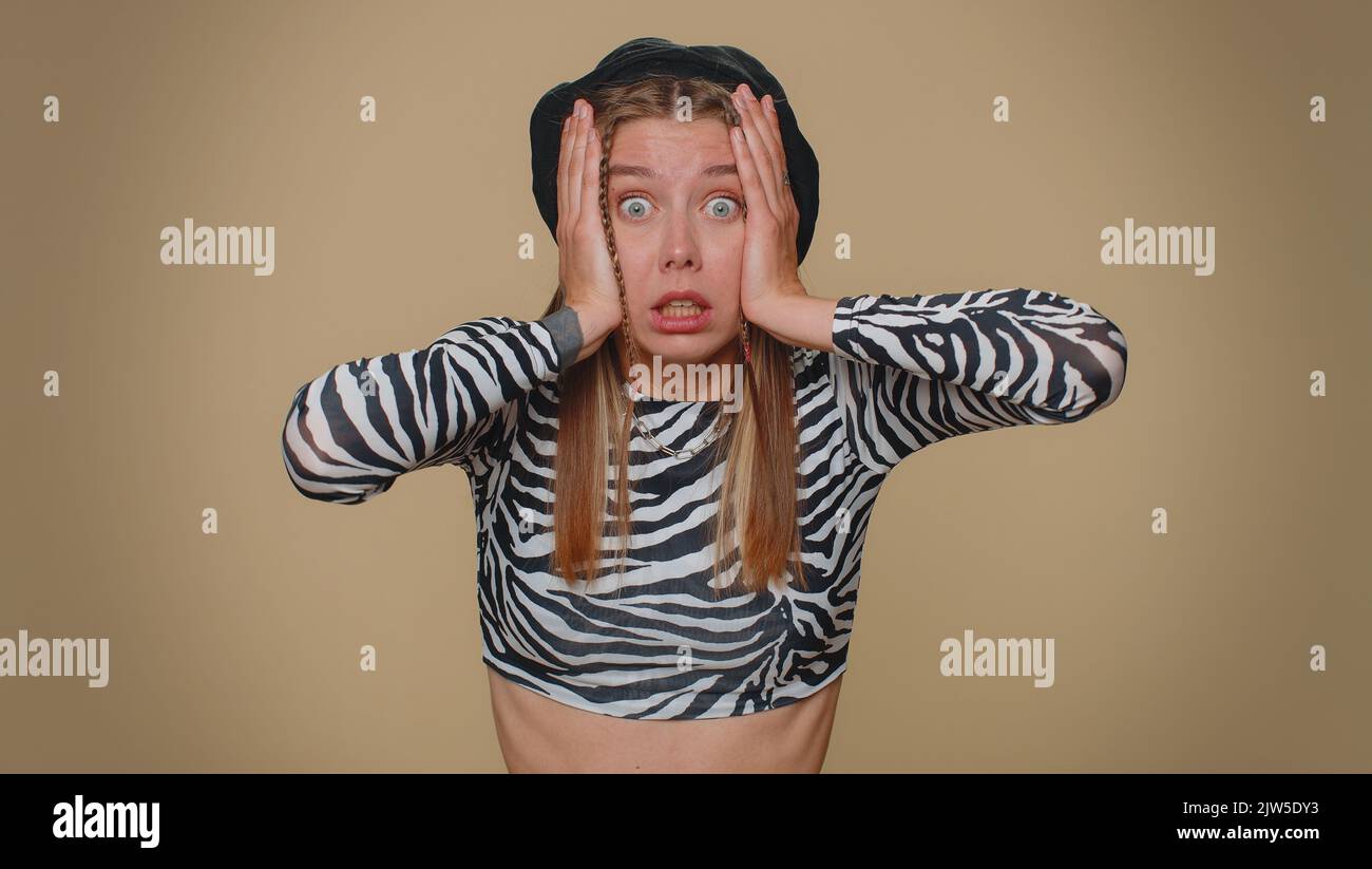 Scared fearful young woman covering ears with hands, closing eyes ...