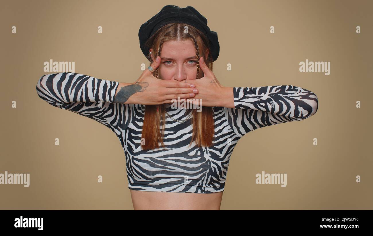 I will not say anyone. Frightened young woman closing her mouth with ...