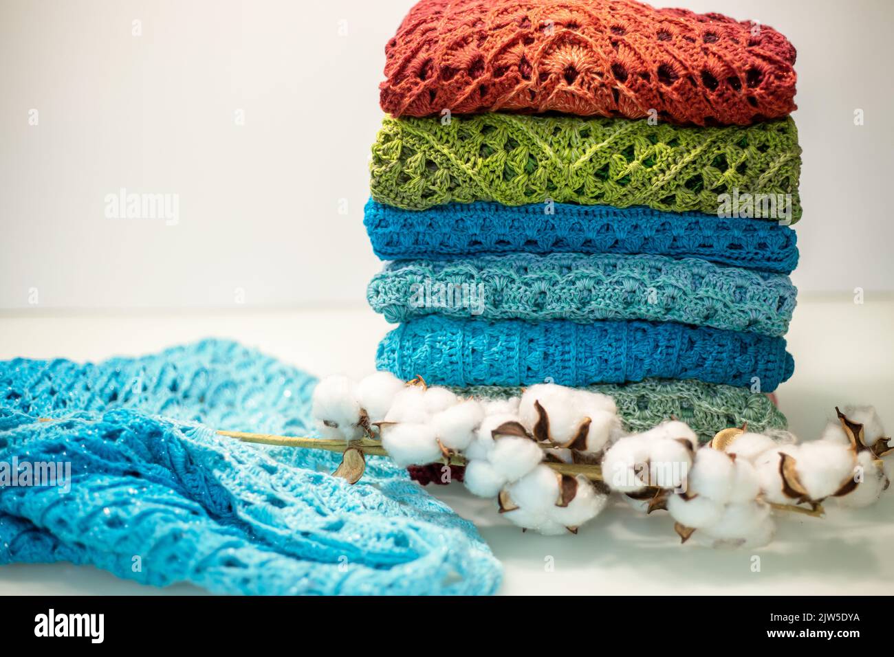 a stack of multi-colored knitted things on a white background Stock ...