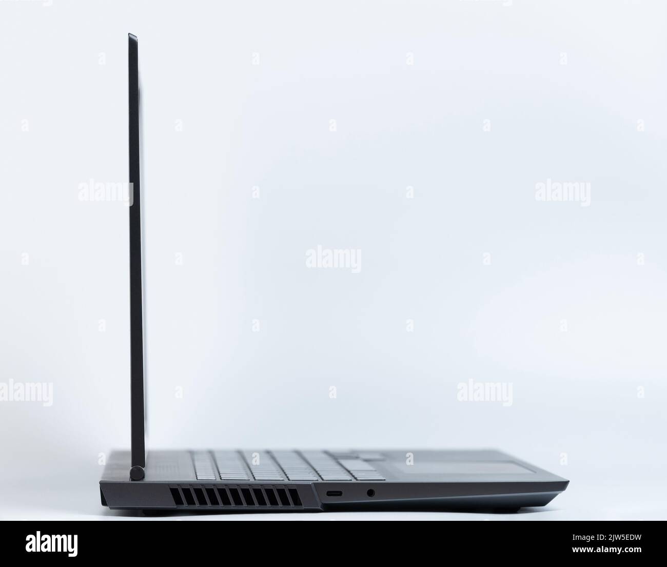 Open black color matal laptop side view isolated on studio background ...