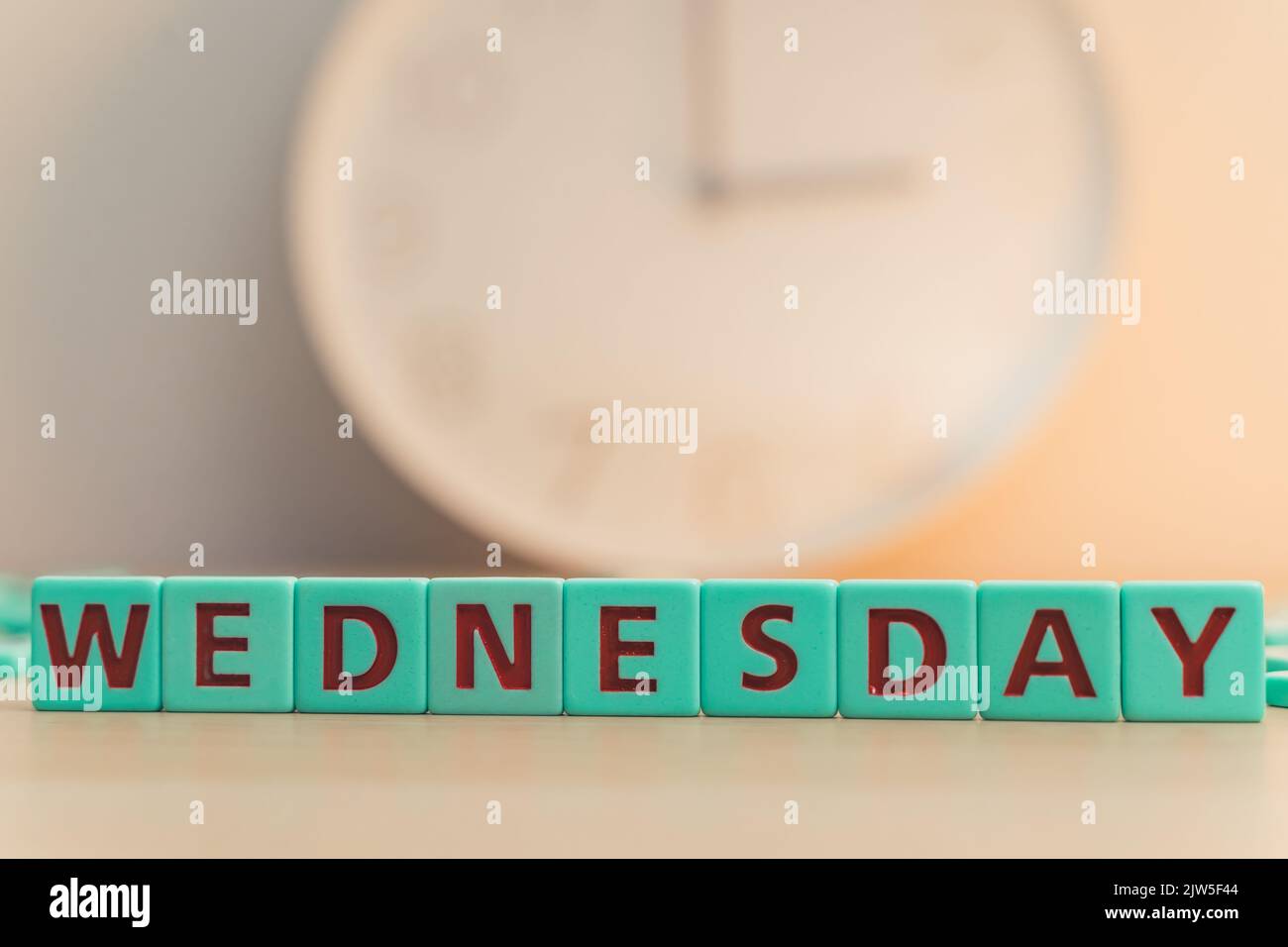 The word WEDNESDAY made of square colorful letters on the table with a ...