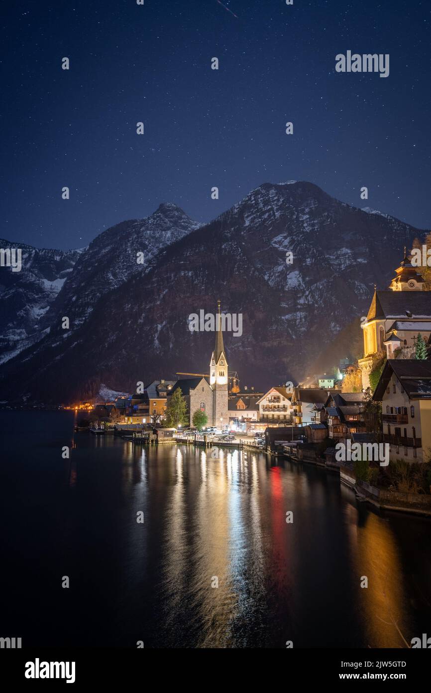Wonderful cozy town on bank of a lake illuminated during night ...