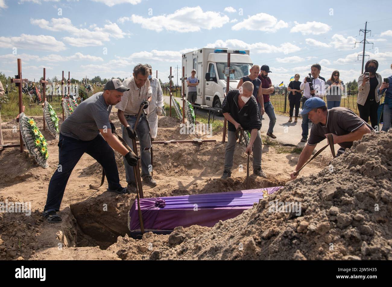 A group of local residents bury unidentified victims of Russian ...