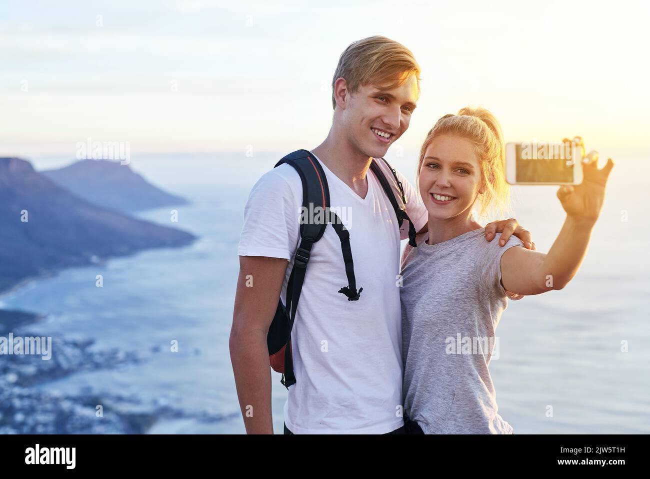 Snapping a selfie on the mountain top. a young couple taking a selfie ...