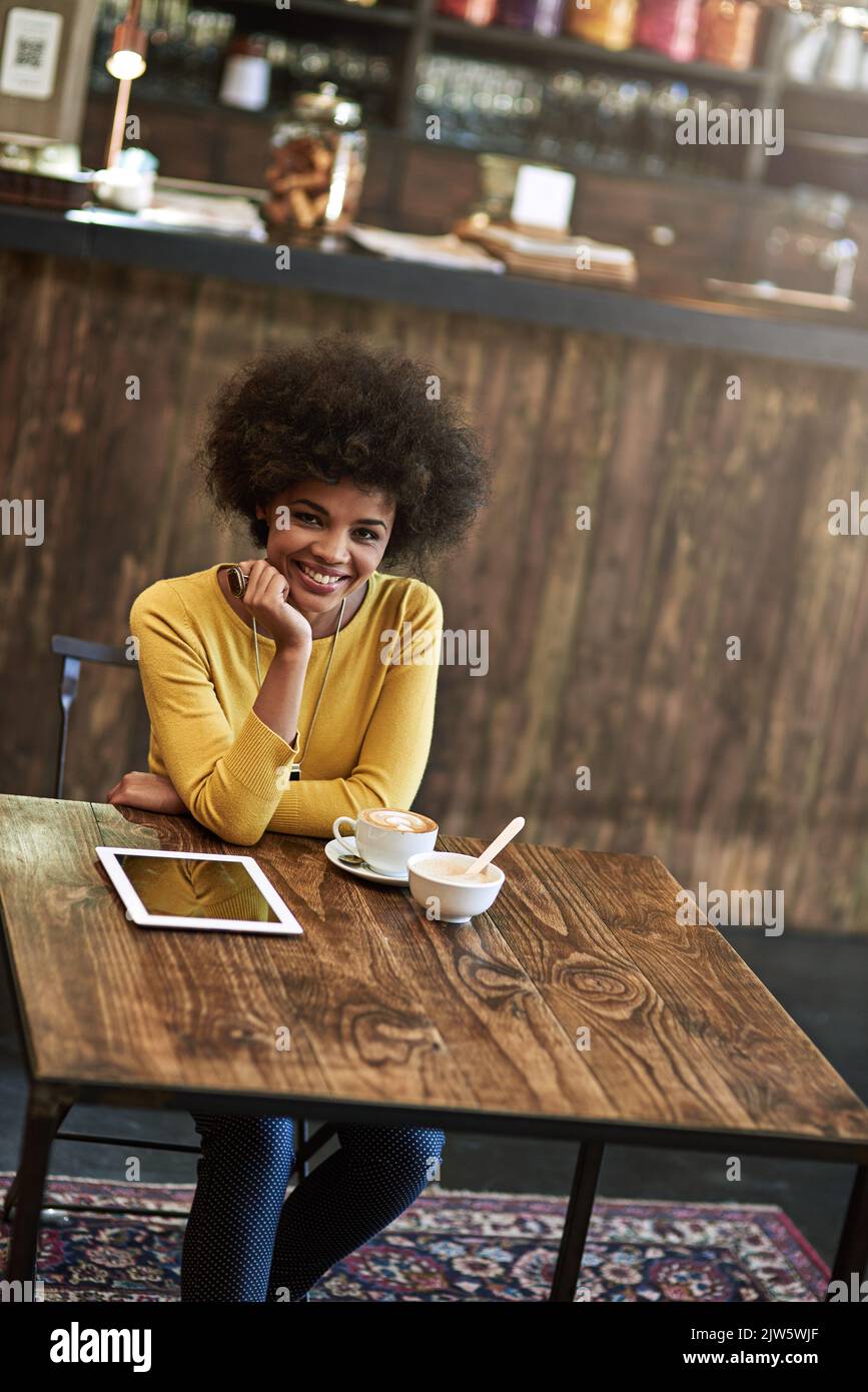 I love coming to this cafe. Portrait of a young woman using a digital ...