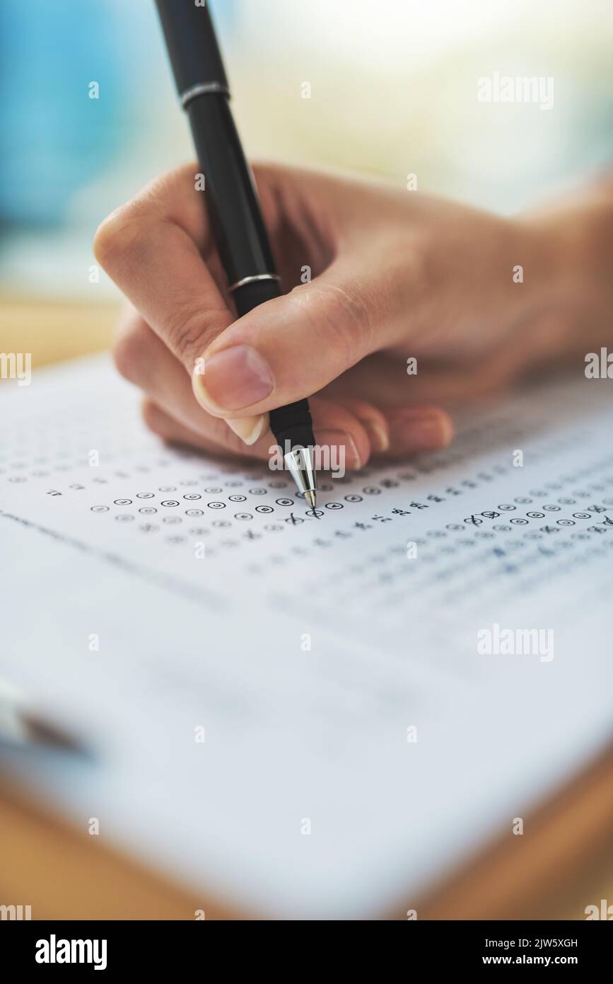 Hoping to pass this test. a woman filling in an answer sheet for a test ...