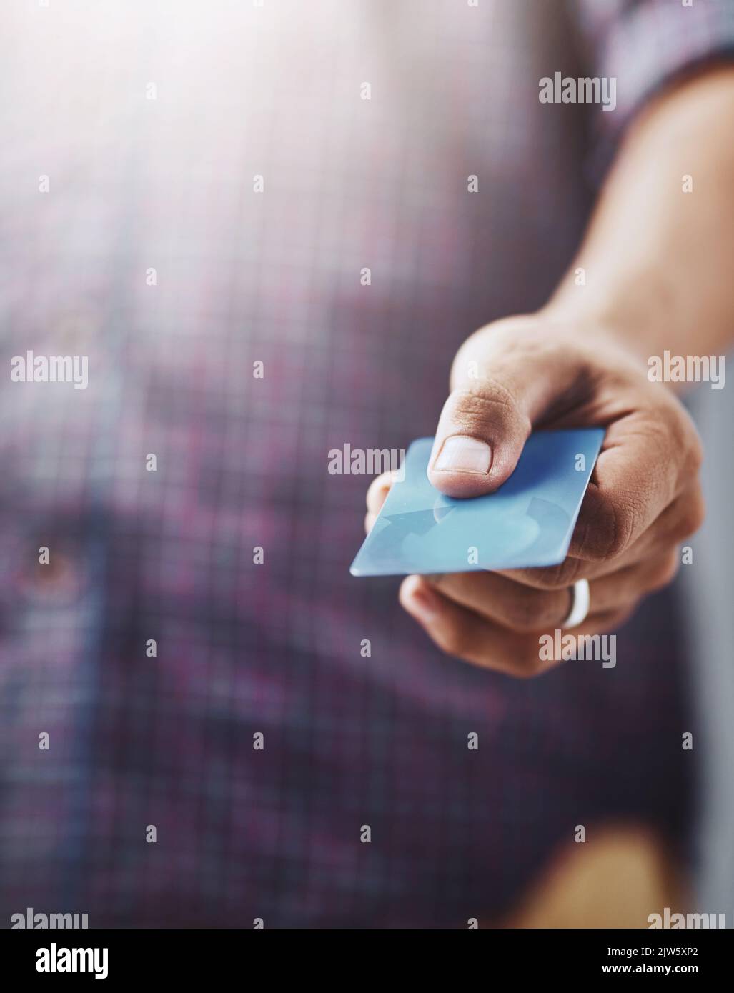 Paying his debts. an unrecognizable man holding his card out to make ...