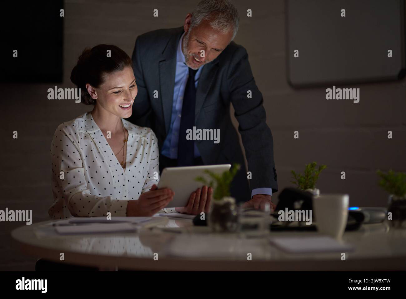 Burning the midnight iol in the office. two colleagues using a digital ...