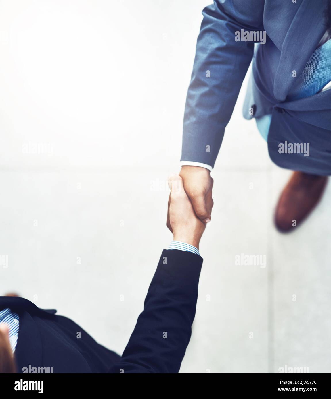 Joining forces. High angle shot of two unrecognizable businesspeople ...