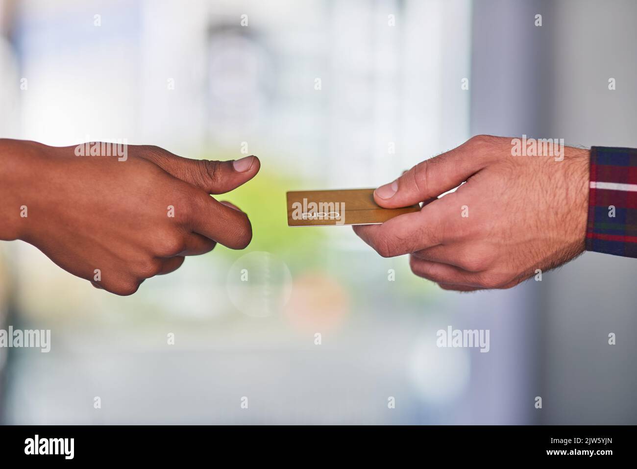 Charge it please. a customer giving his credit card to a store clerk ...