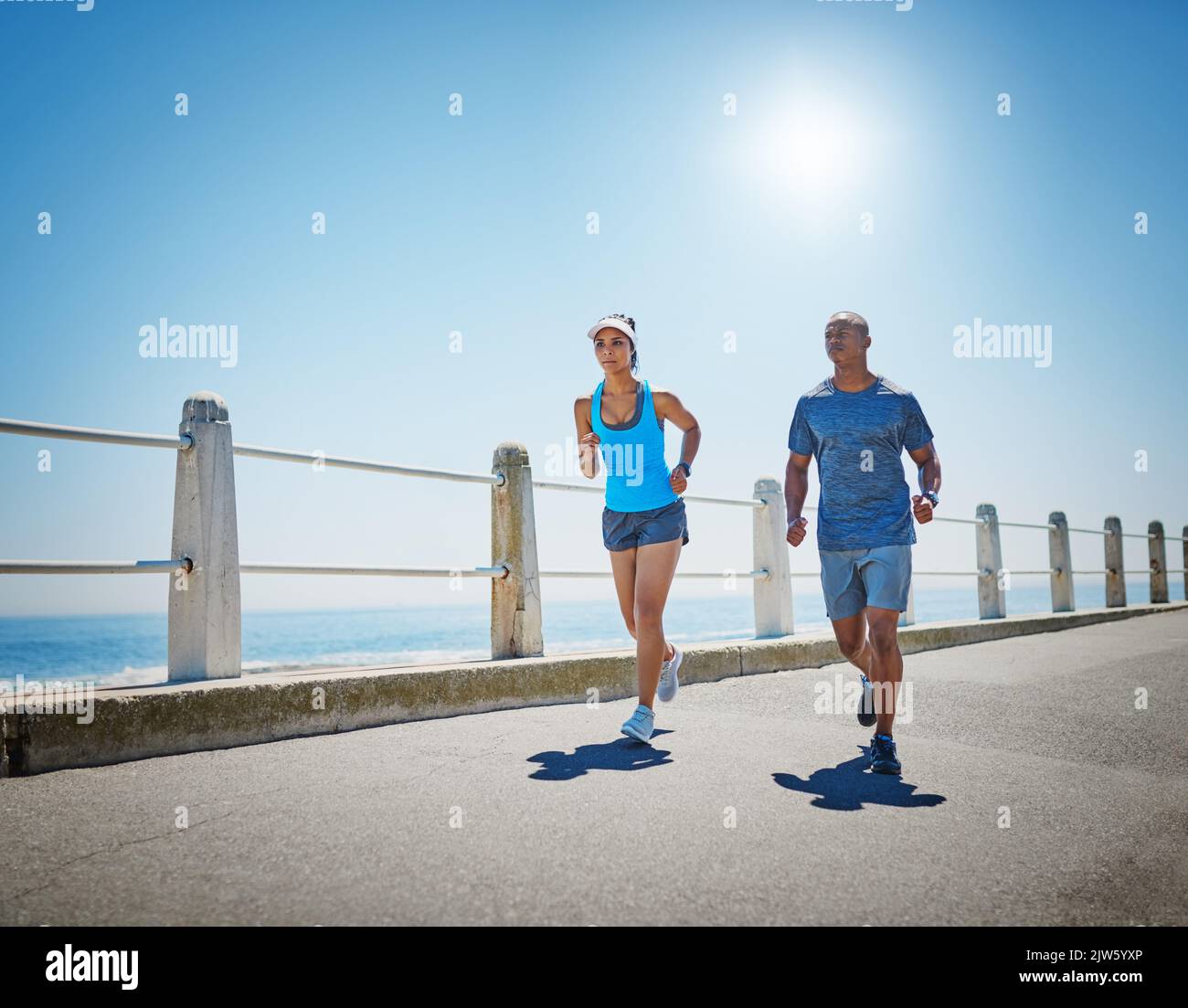 Persevering together. a young sporty couple out for a run together ...