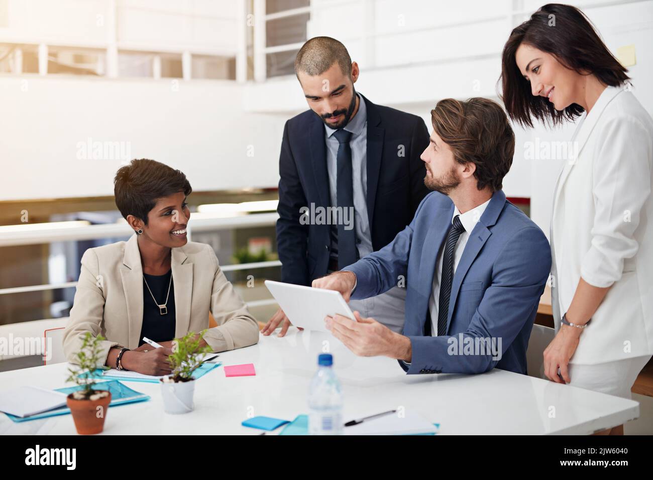Combining their efforts together. businesspeople using a digital tablet ...