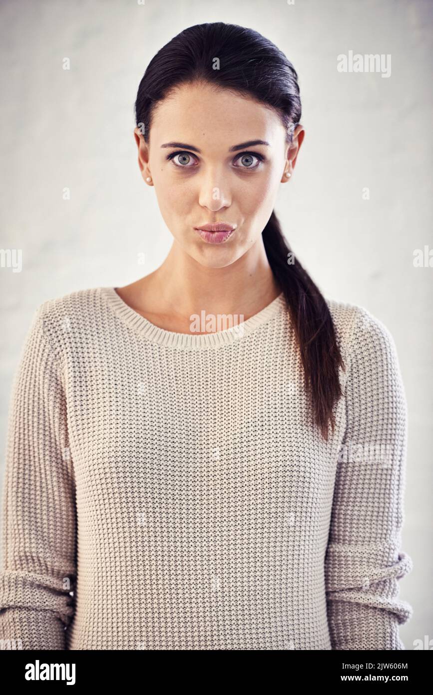 Lets get serious. Portrait of a serious looking young woman standing ...