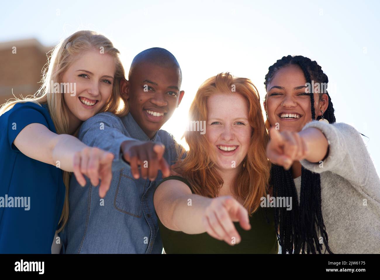 You can make a difference. Portrait of a group of people pointing their ...
