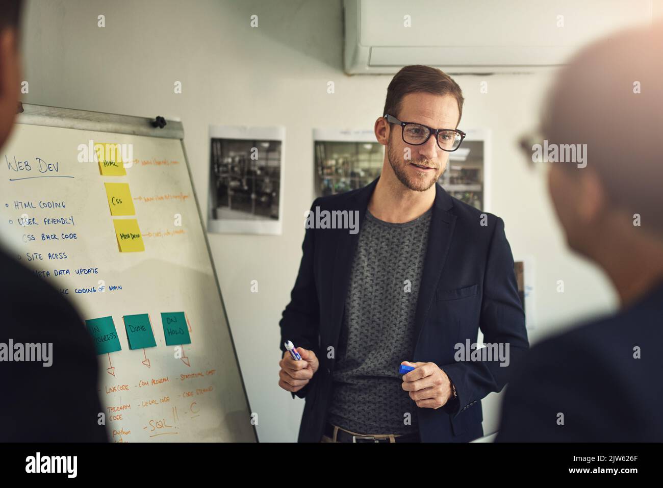 Charting their teams progress. a young man giving a presentation to ...