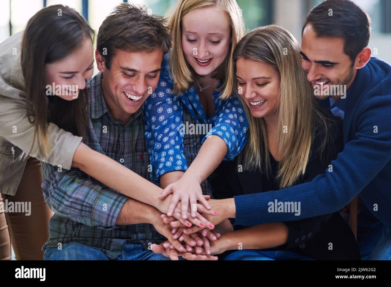 Huddle around the team. a group of people putting their hands together ...