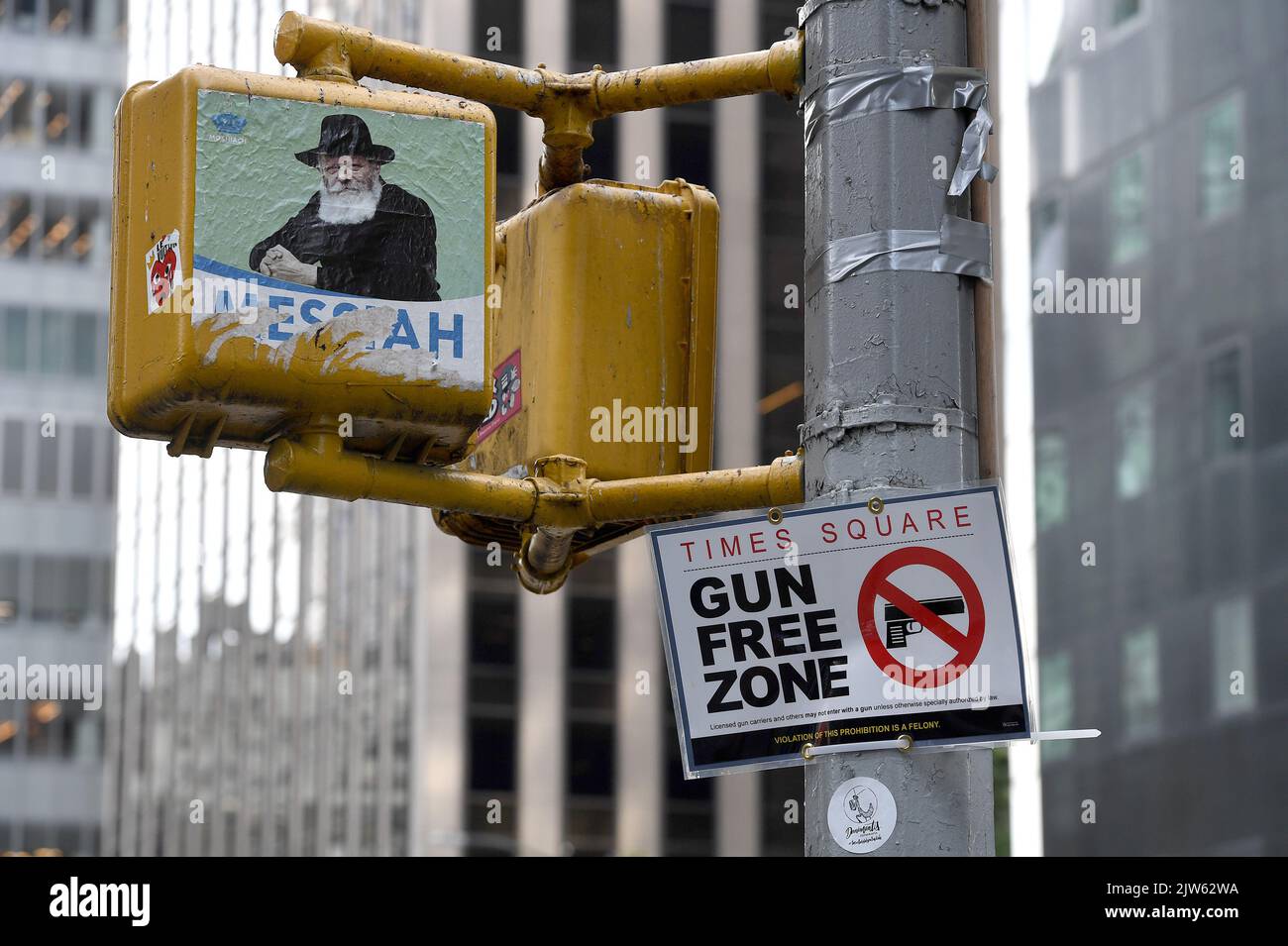 “Gun Free Zone” signs are attached to a traffic light pole along Sixth ...