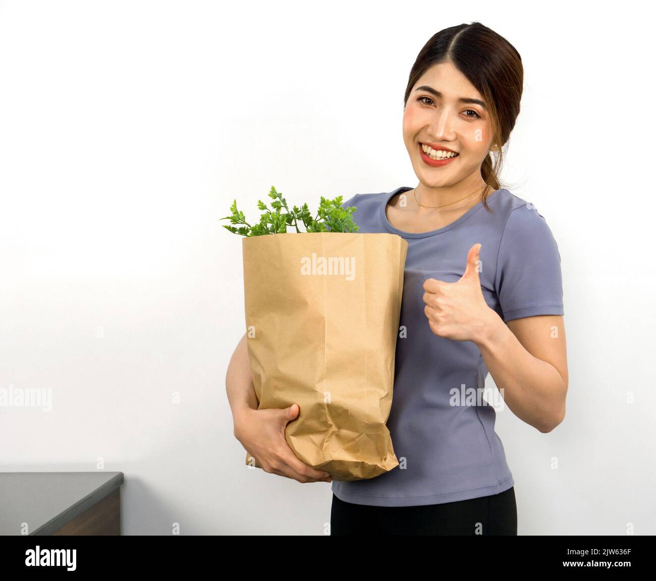 Young asian woman in casual wear stand with a smile, raise finger thumb ...