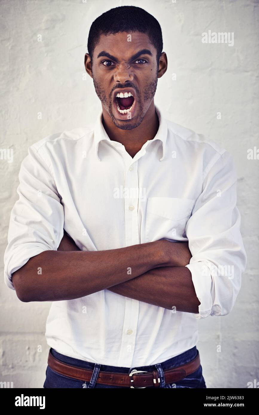 I couldnt be any angrier right now. Portrait of a young man standing ...