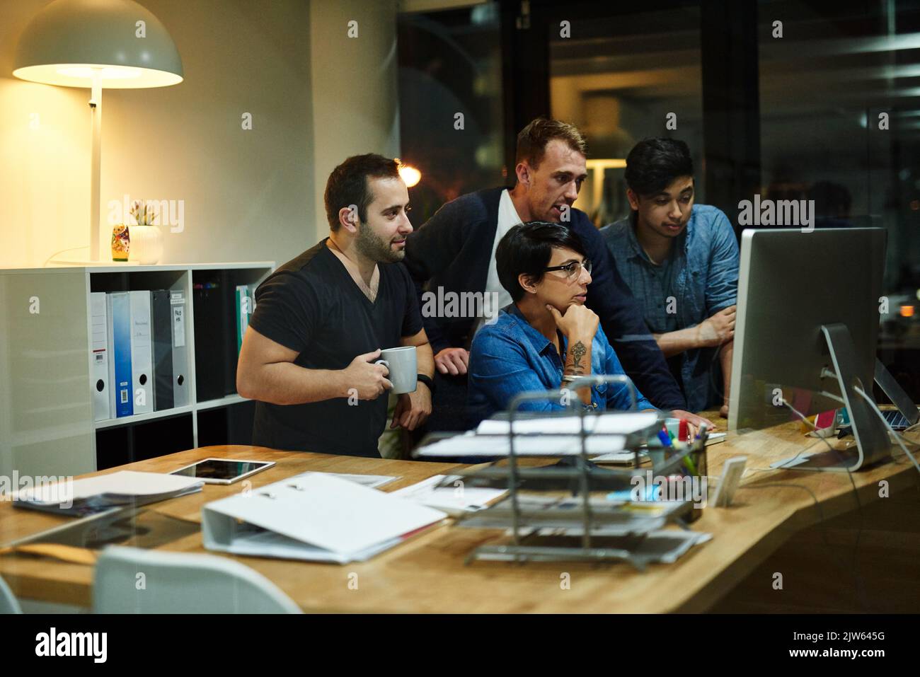 Teamwork at its best. employees working in an office at night Stock ...