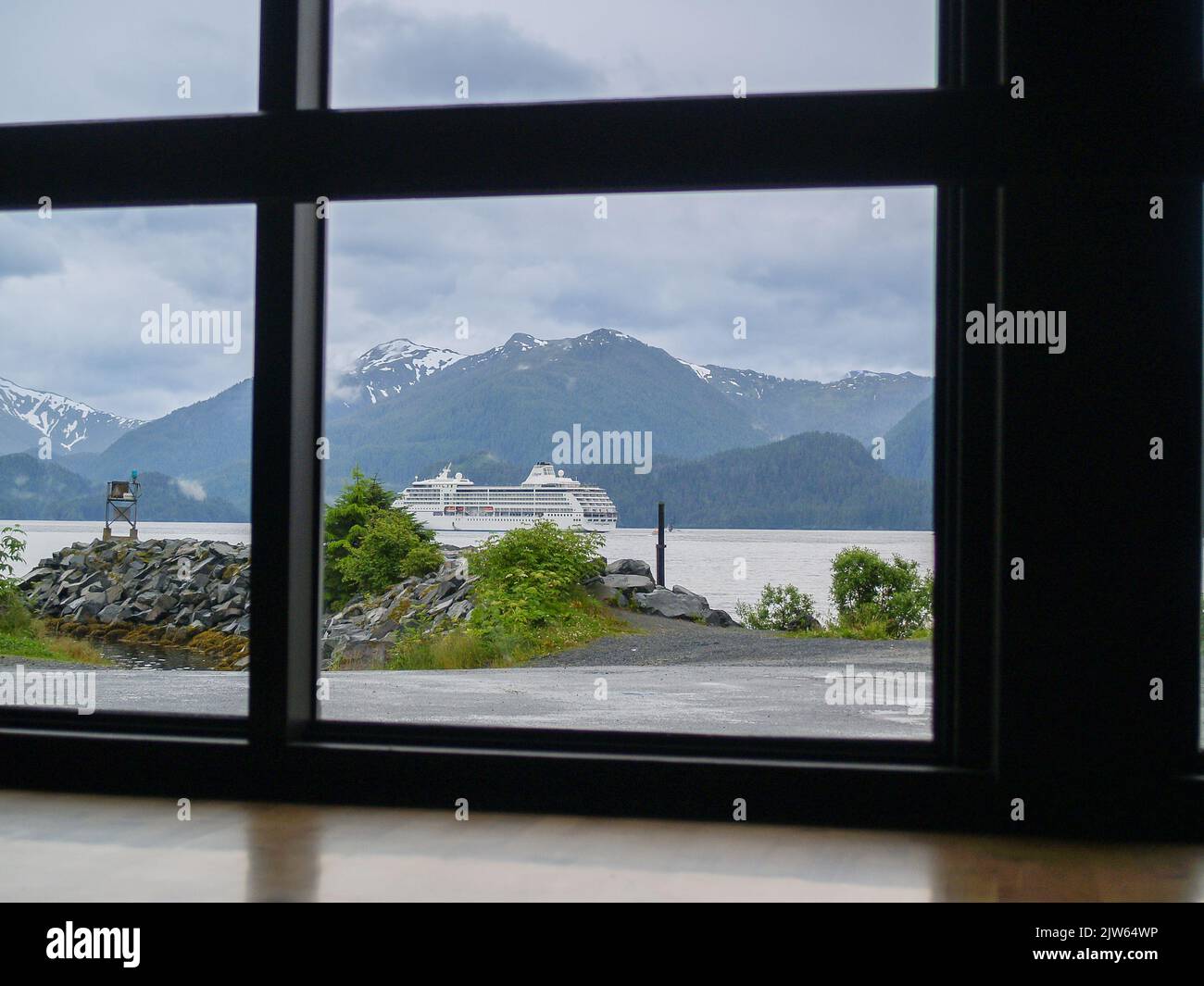 View through window of dramatic Alaskan scenery and passing cruise-ship ...
