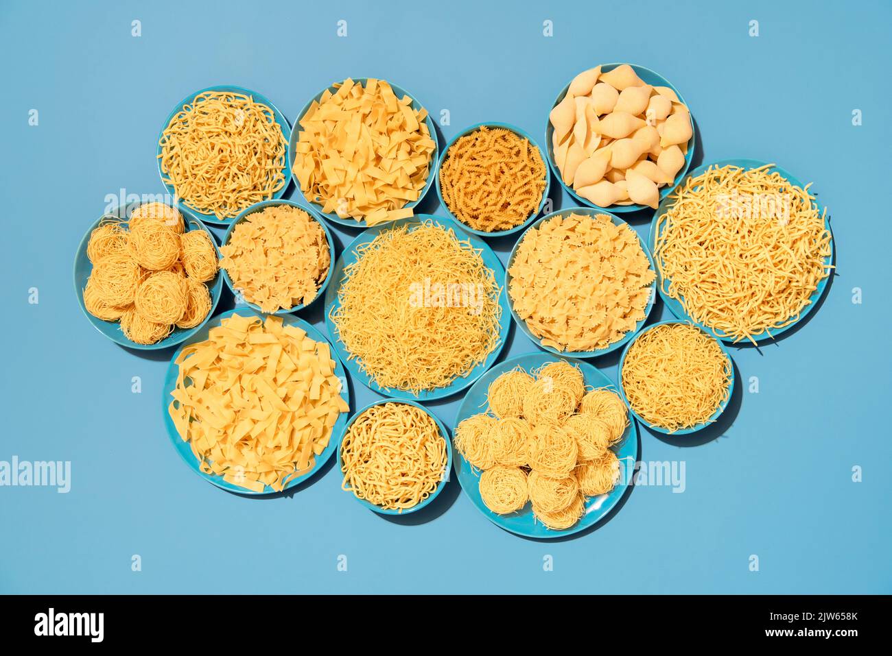 Above view with a large variety of pasta on blue plates, on a blue ...