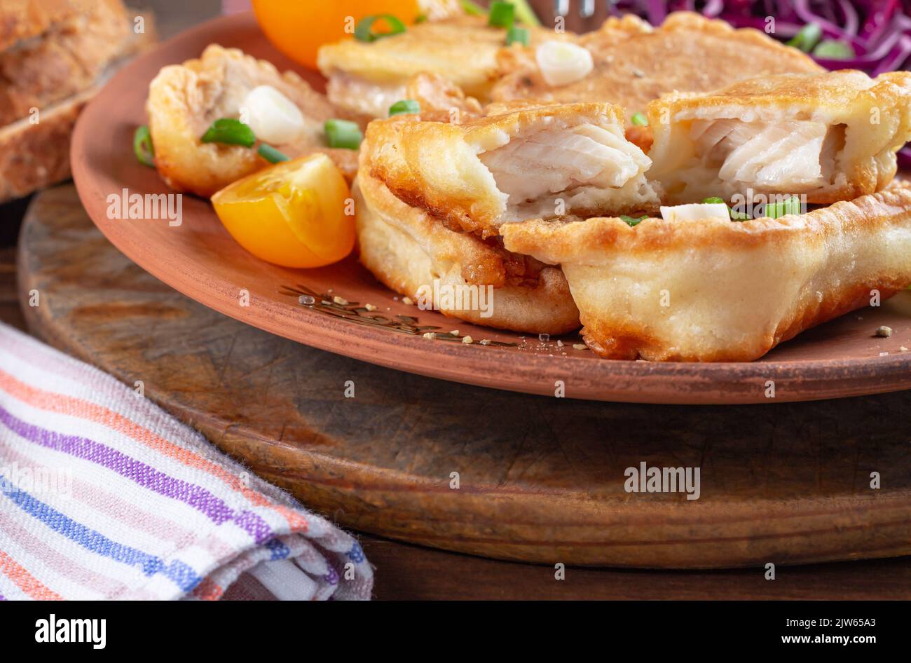 Front, close view of several pieces of tilapia battering with yellow ...