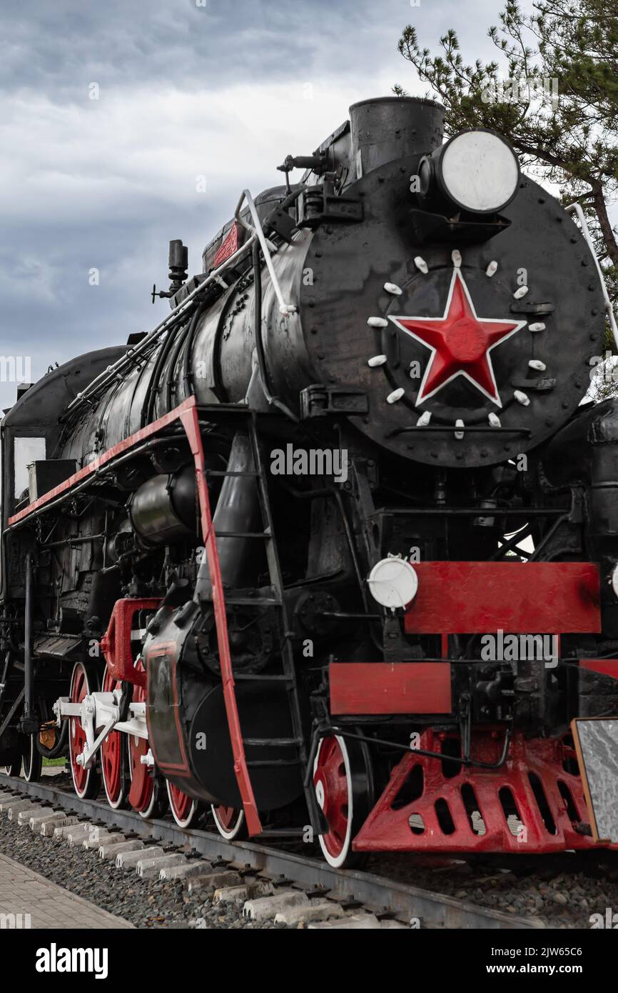 Outdoor vintage or museum exhibit, Black Locomotive with red wheels red ...