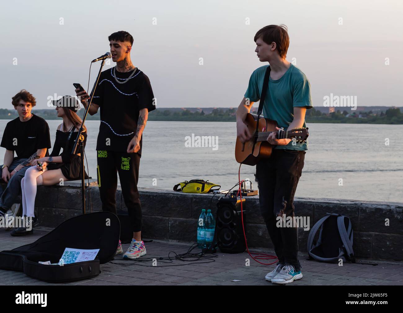 Boy electric guitar playing for people. Males on musical instruments in ...