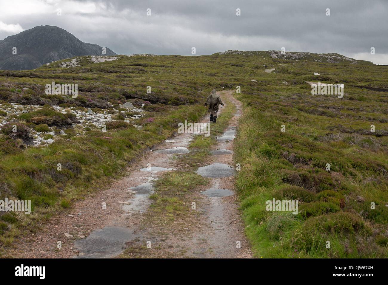 Walker on a wet bridleway, Uig, Lewis, Isle of Lewis, Hebrides, Outer ...