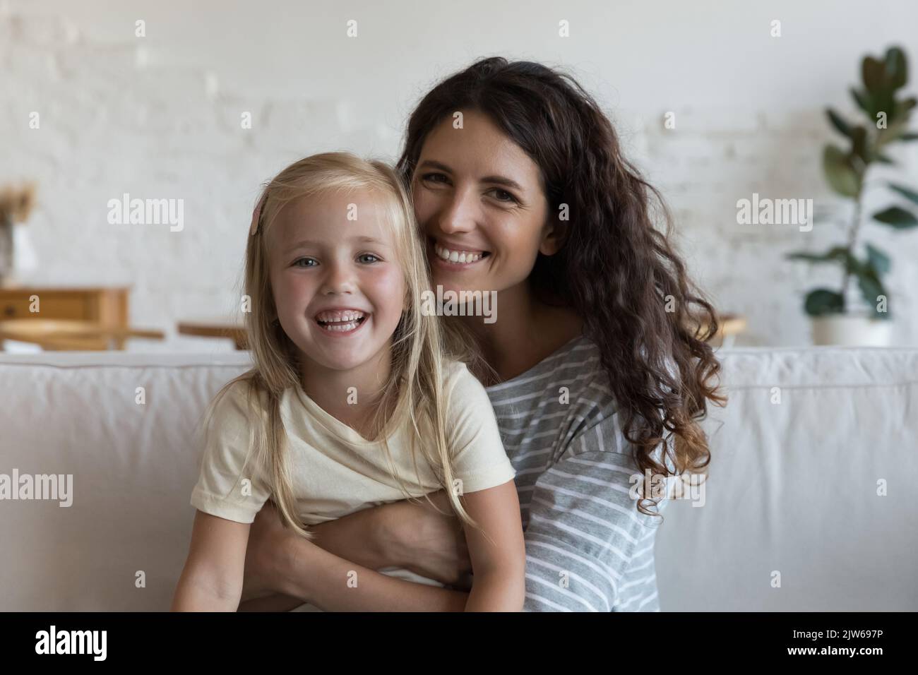 Loving mother hugs daughter smiling pose on camera Stock Photo - Alamy
