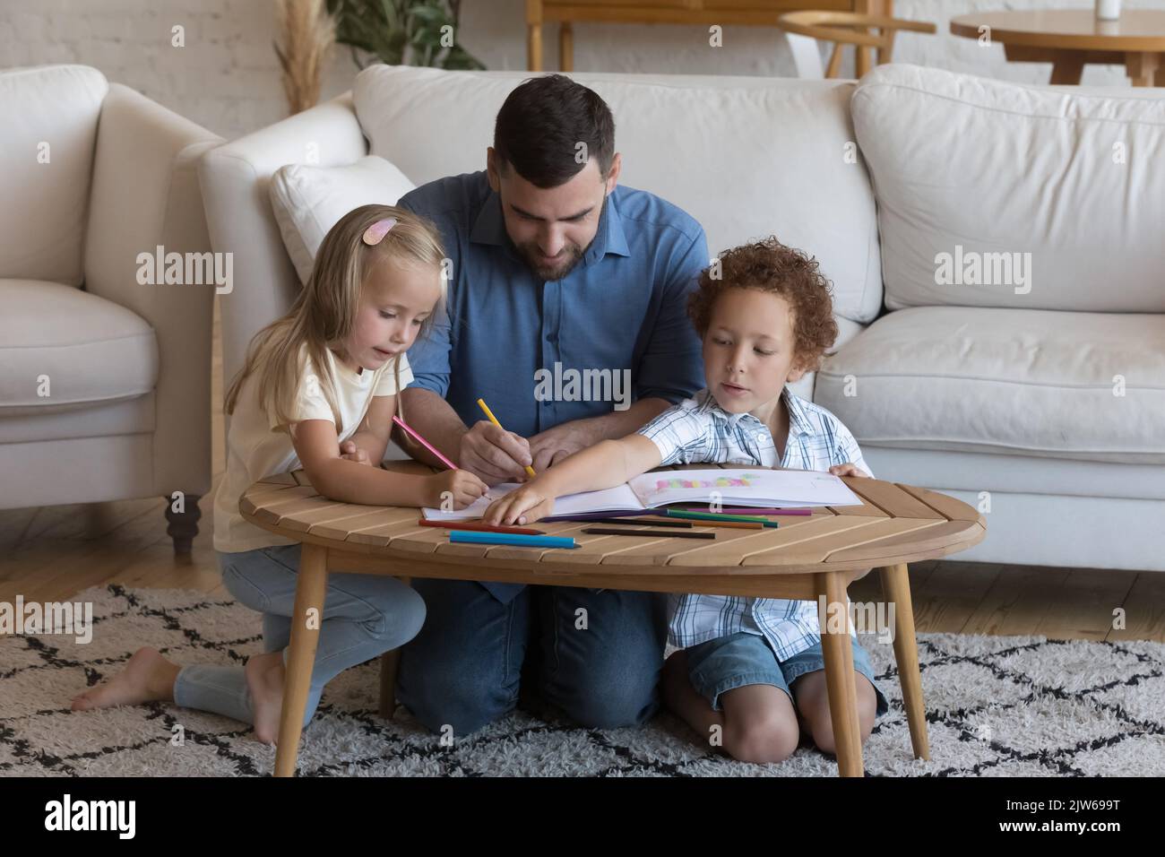 Father and siblings drawing pictures with pencils in sketchbook Stock ...