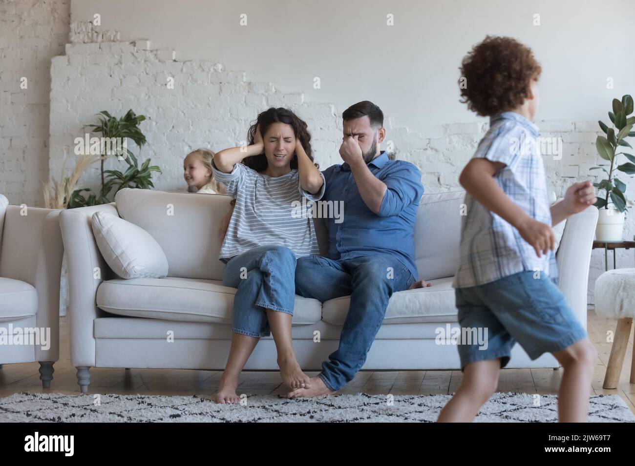 Little active children make noise, running around of annoyed parents ...