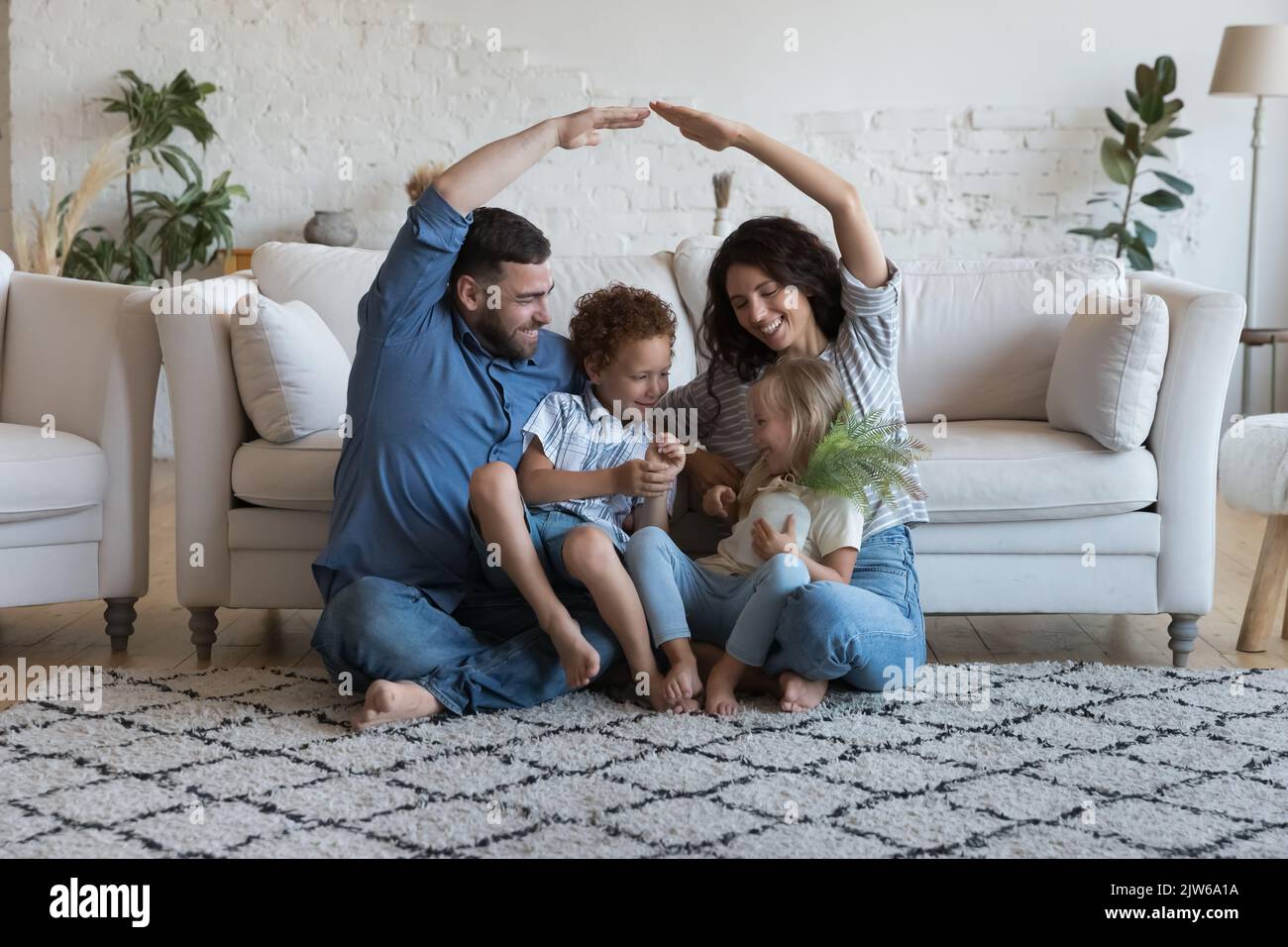 Family with kids sit on floor at their new home Stock Photo - Alamy