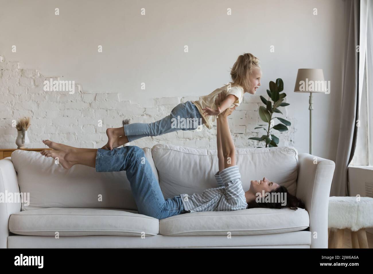 Woman lying sofa arms hi-res stock photography and images - Alamy