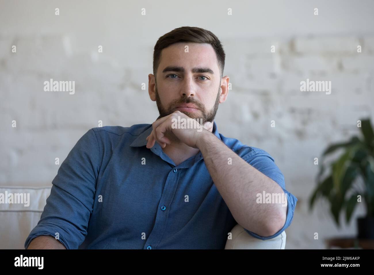 Man sit on couch in living room staring at camera Stock Photo - Alamy