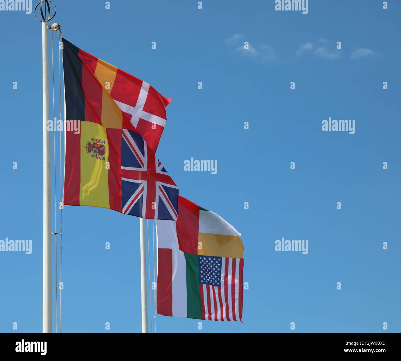 flags of many different nations flying against the blue sky background ...