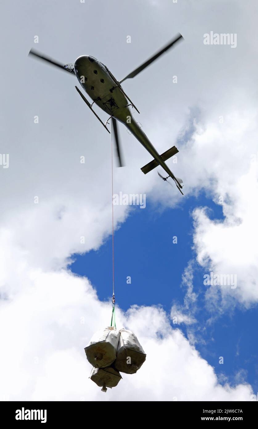 flying helicopter with three blades in the sky as it transports large ...