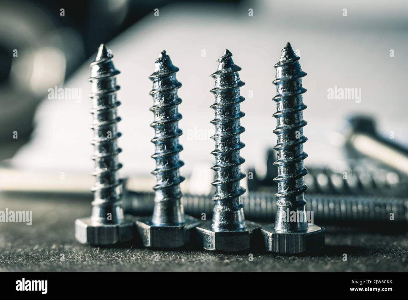 A closeup shot of metallic bulk blots on a black table surface with ...