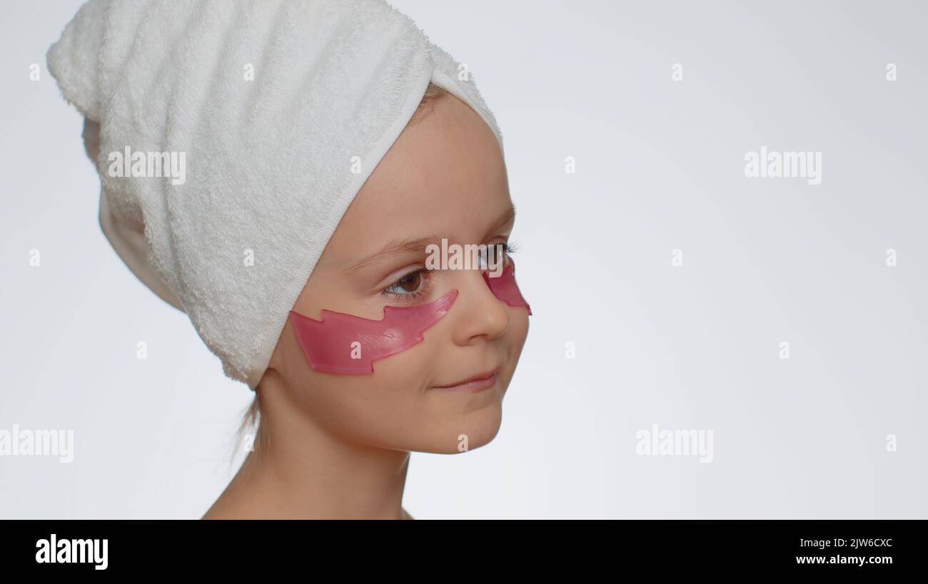 Beautiful young smiling child girl in towel on head applying pink ...