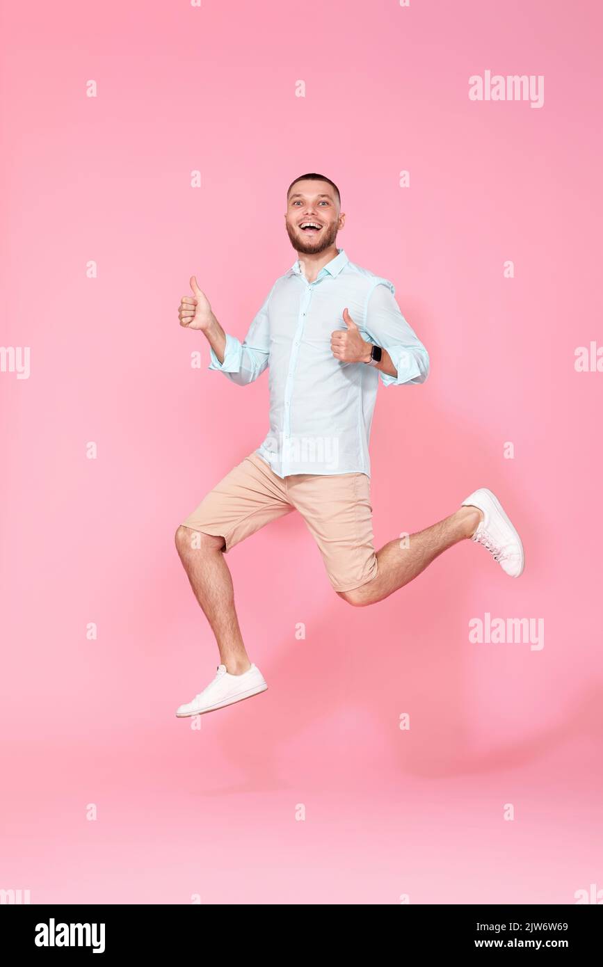 man in summer clothes jumping on pink background Stock Photo - Alamy
