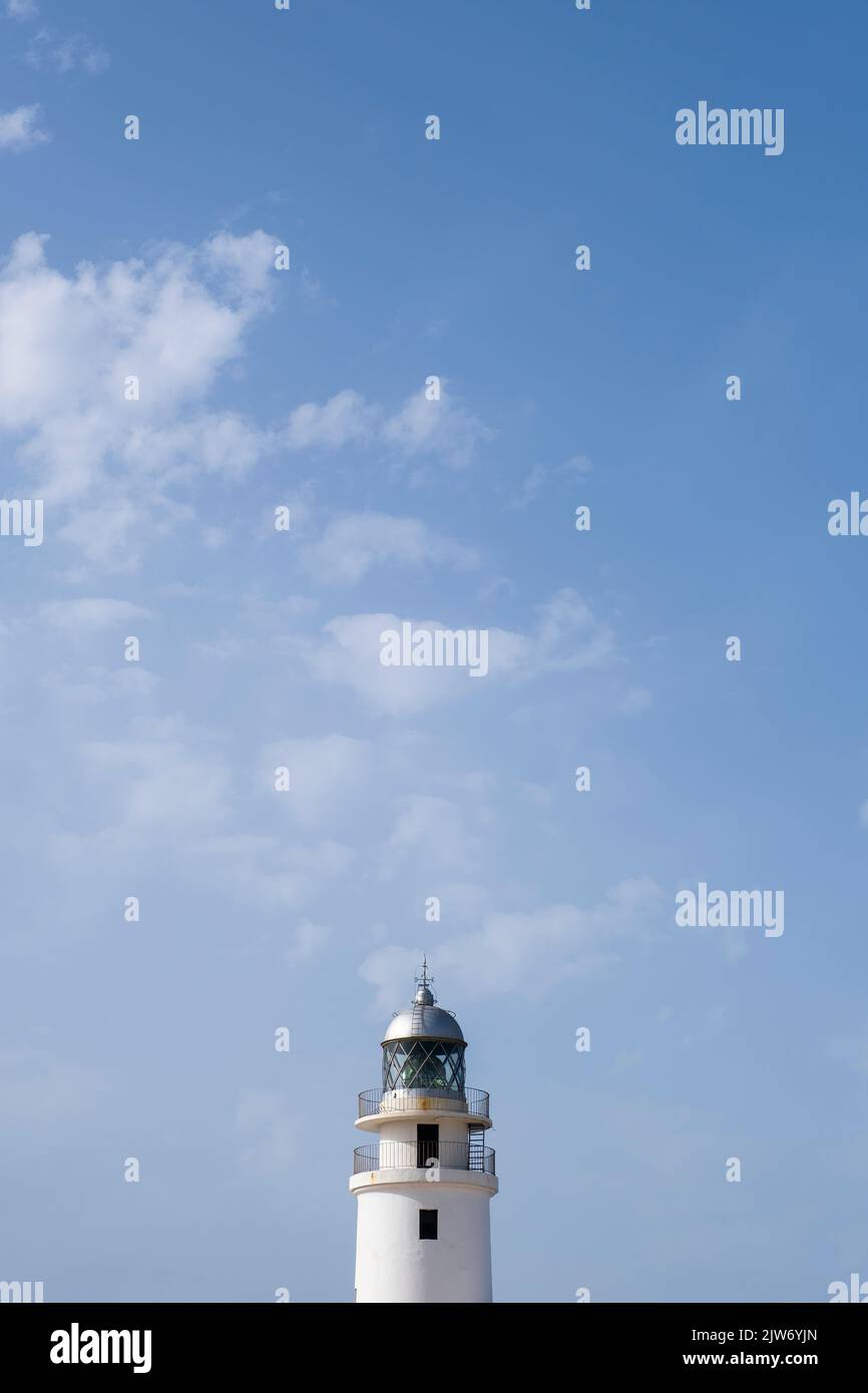 tip of a white lighthouse with a weather vane on the roof, a blue sky ...