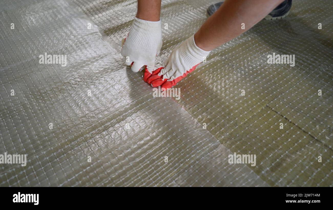 Laying a film on waterproofing on the floor. The master installs a film ...