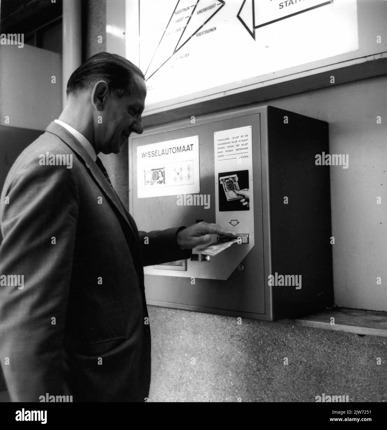 Image of a man at a money change machine in the N.S. station Utrecht et ...