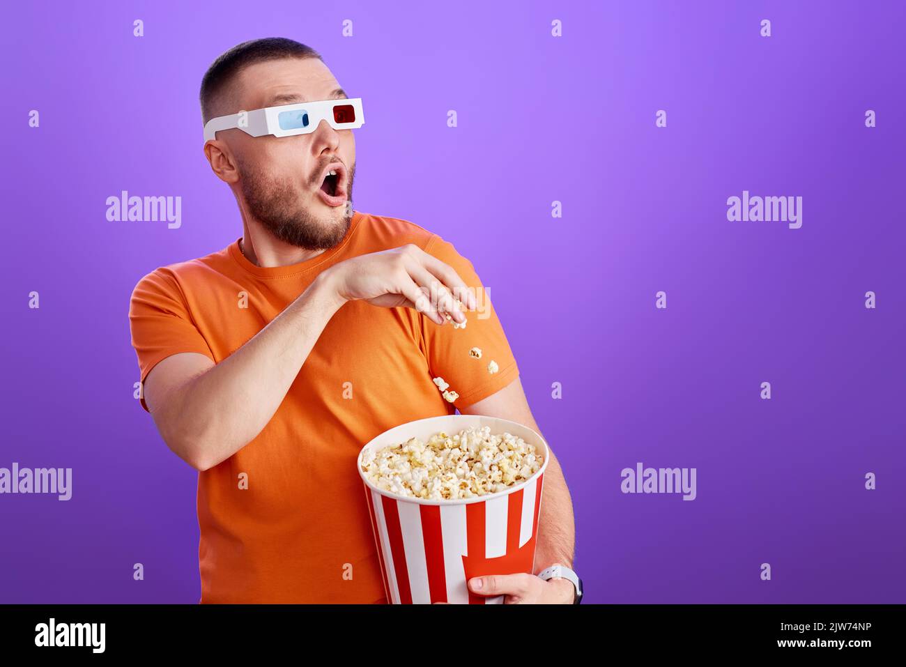 Young caucasian man in 3d glasses eating popcorn Stock Photo - Alamy