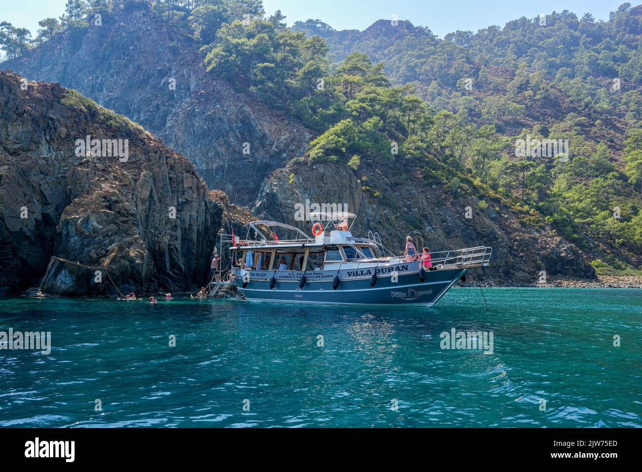 A boat moored at the bay and people swimming. Boat tours are made to ...
