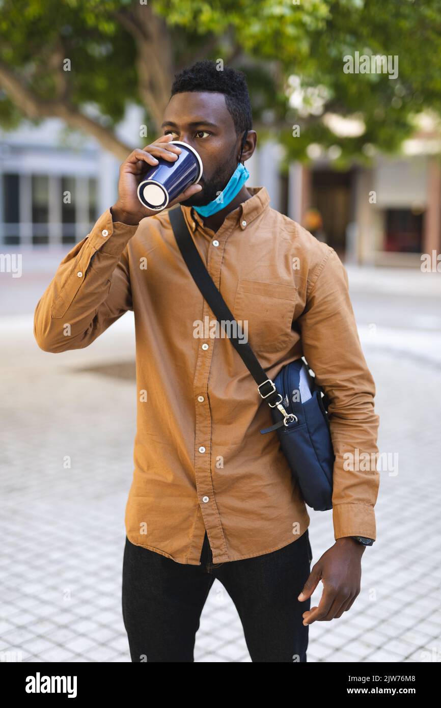 African american man walking and drinking coffee Stock Photo - Alamy