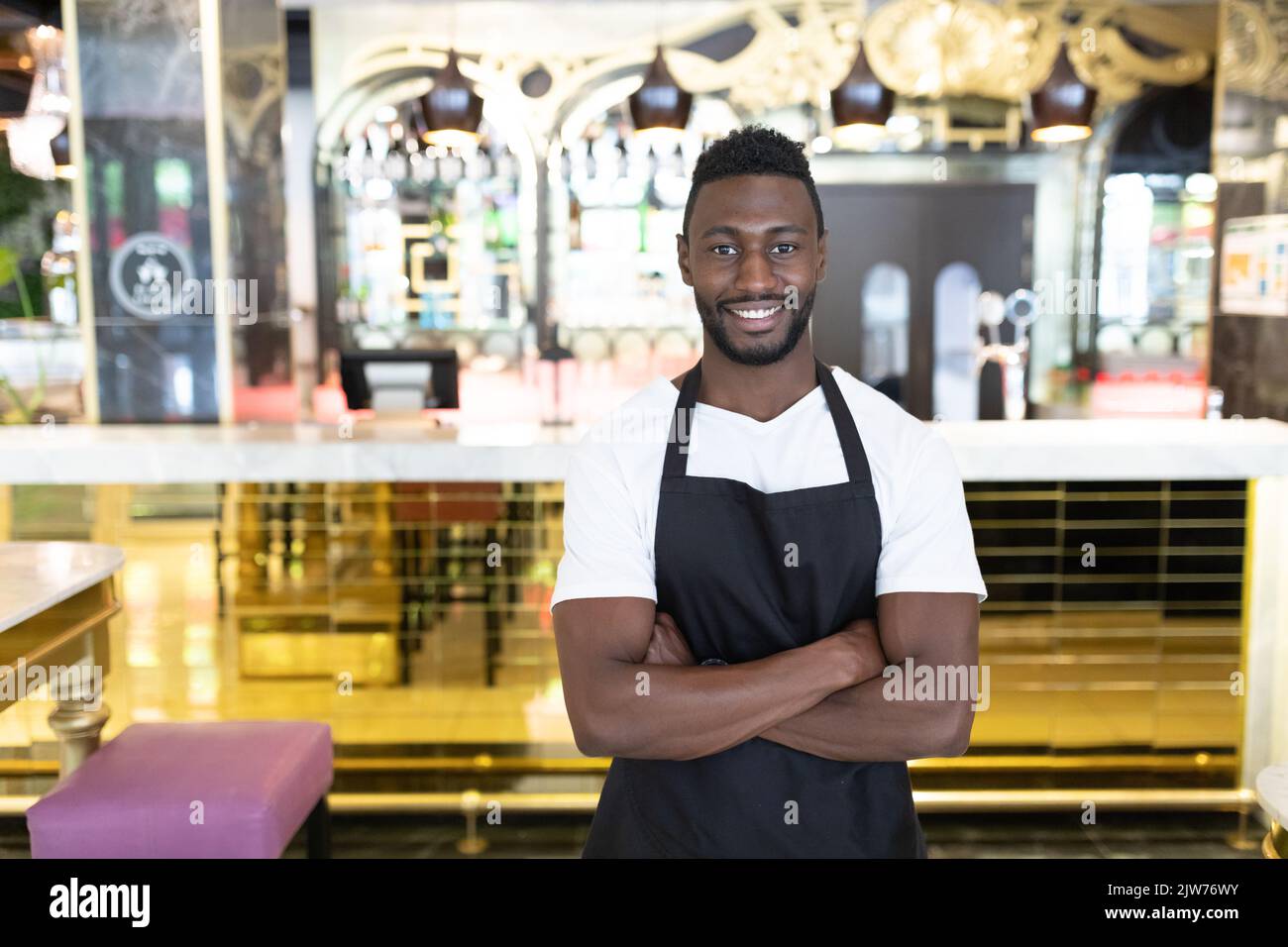 Portrait of african american male barista looking at the camera and ...