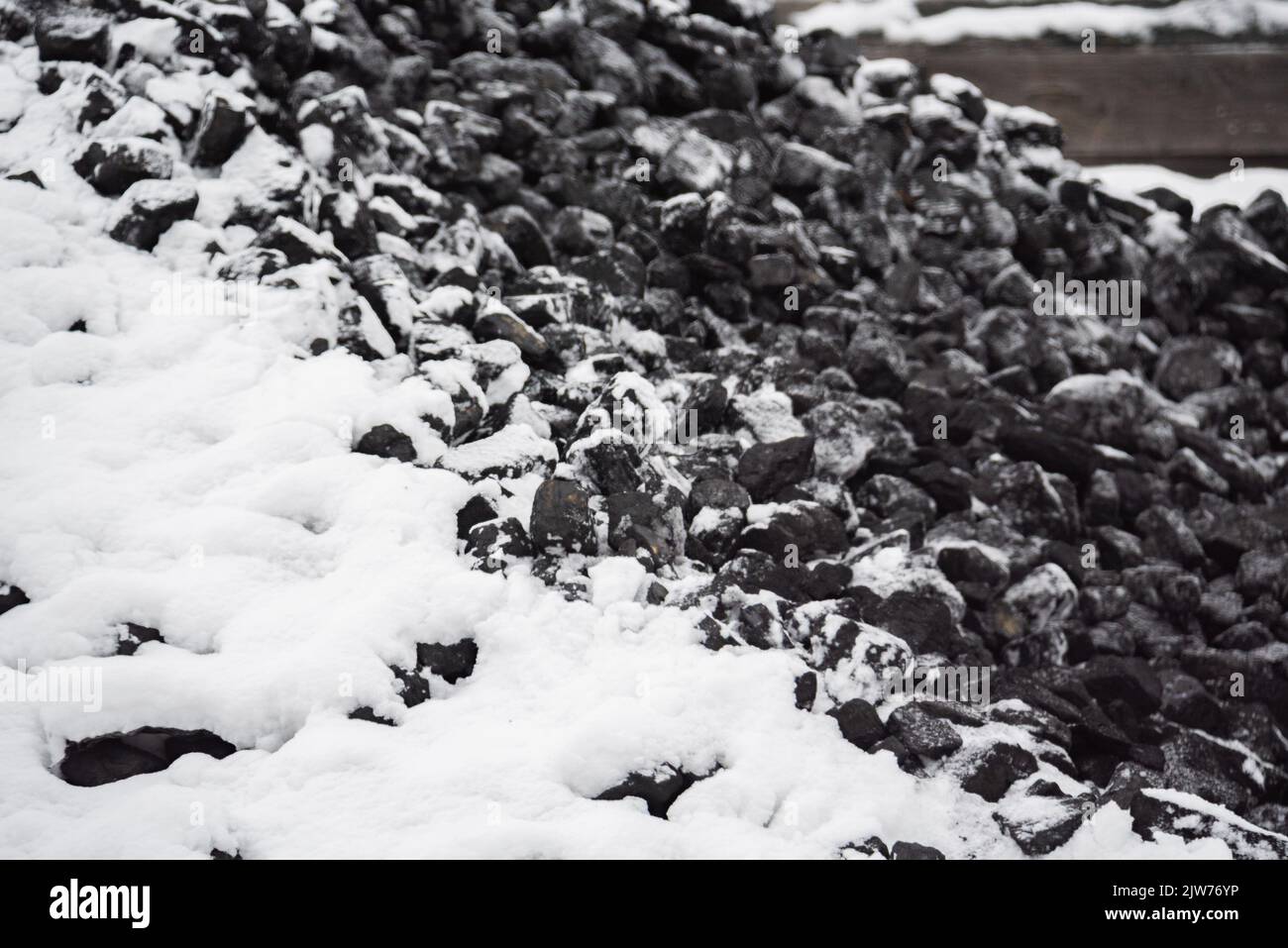 Coal covered with snow in the fuel store. Sale of coal in winter. Coal ...